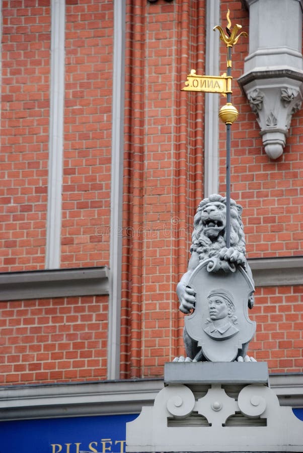 Vertical Shot of a Statue Against a Brick Wall in Riga Stock Image ...