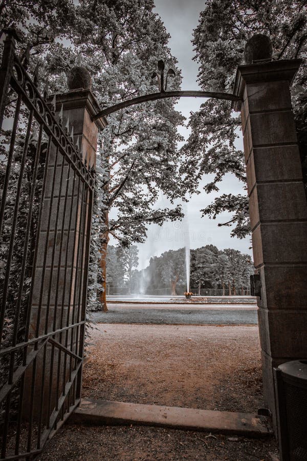 Vertical Shot of a Steel Gate and a Fountain Inside Stock Photo - Image ...