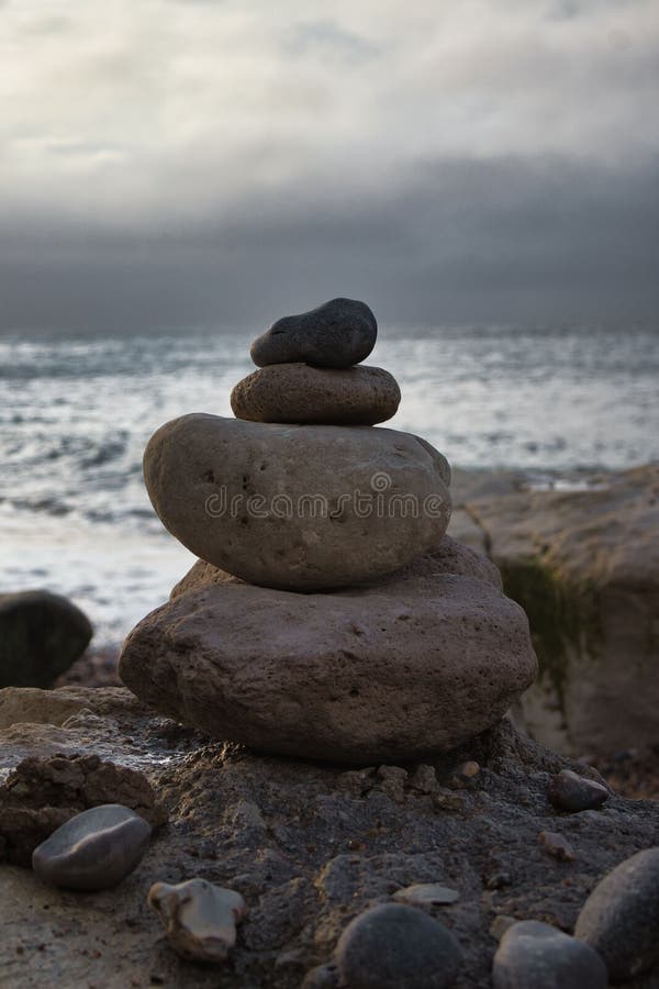 Vertical Shot of a Stone Balance on the Beach and Sea in the Background ...