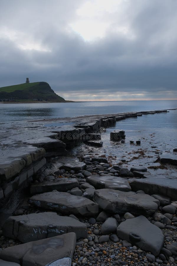 Vertical Shot of a Stone Dock on the Beach during a Cloudy Weather ...
