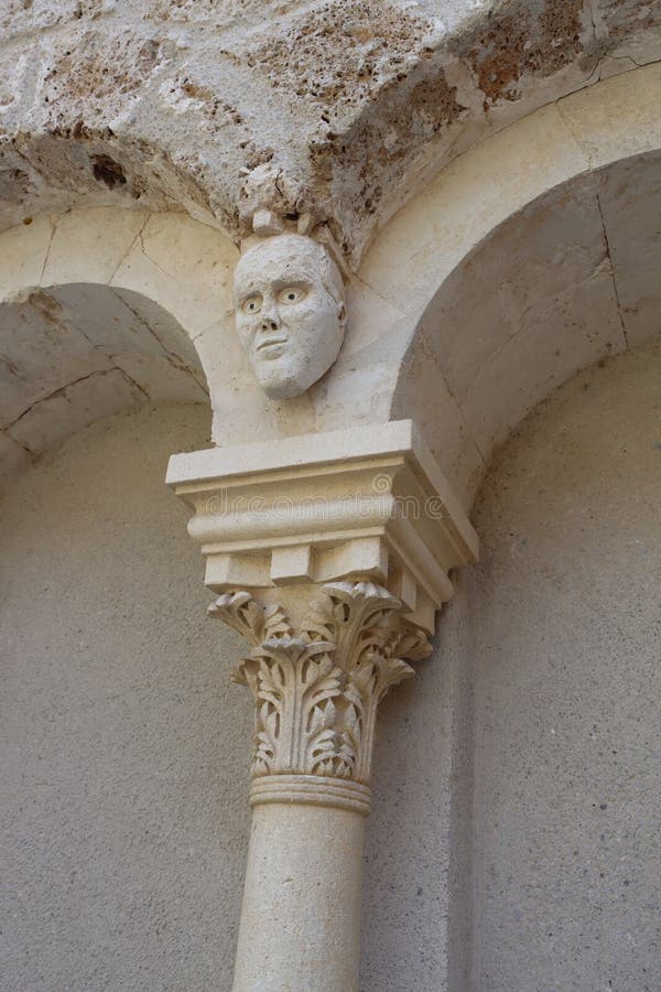 Vertical Shot of a Stone Face on a Column with Two Vaults of an Old ...