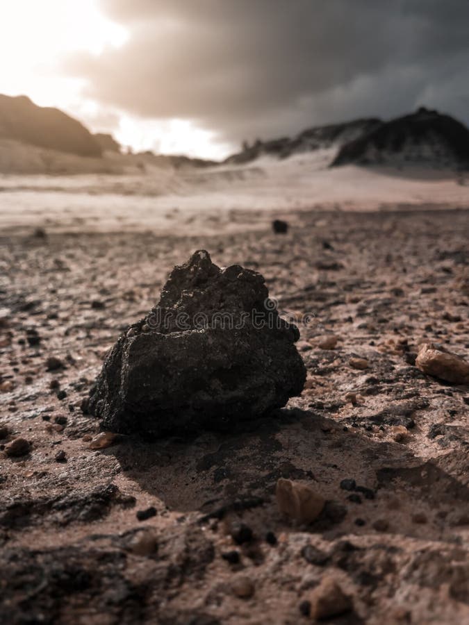 Vertical Shot of a Stone on Ground of Rough Landscape Against Blur ...