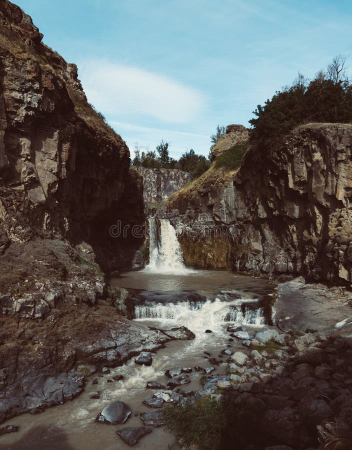 Vertical Shot of a Strong Waterfall Flowing in the River between ...