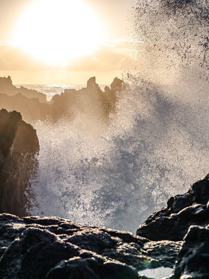 Vertical Shot of Strong Waves Hitting Big Rocks on a Shore with Water ...