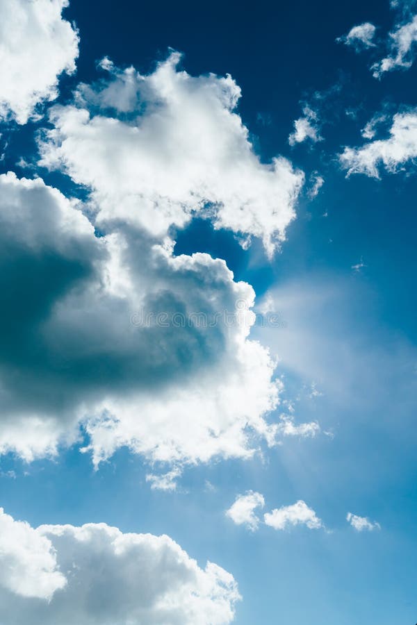 Vertical Shot of the Sun Shining Behind the Clouds Stock Image - Image ...