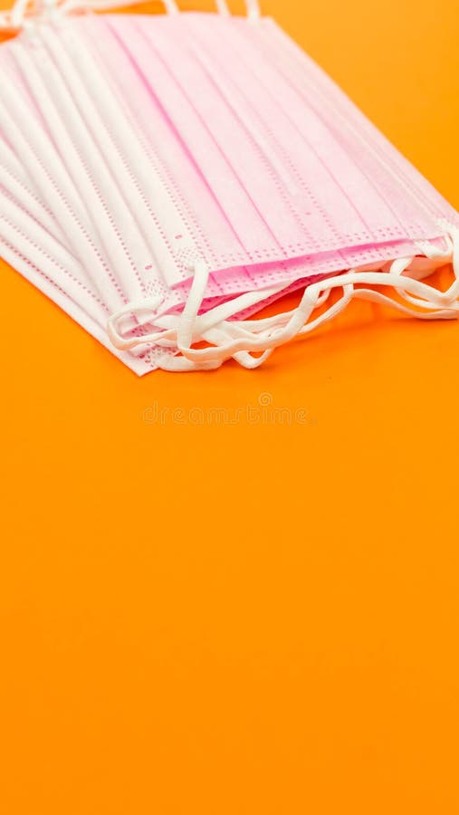 Vertical Shot of Surgical Masks on an Orange Surface Stock Photo ...