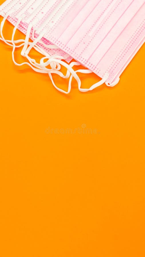 Vertical Shot of Surgical Masks on an Orange Surface Stock Photo ...