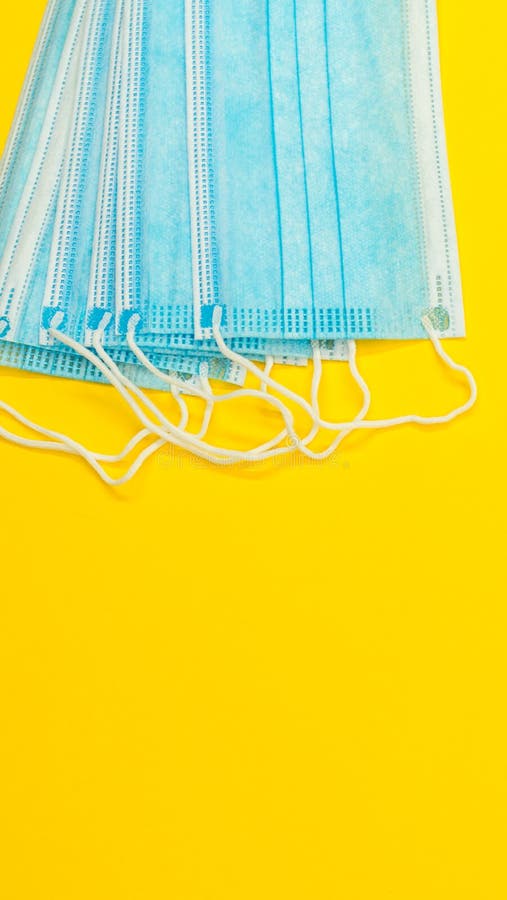 Vertical Shot of Surgical Masks on a Yellow Surface Stock Photo - Image ...