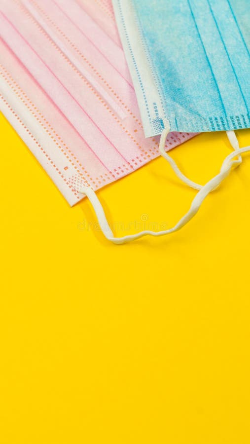 Vertical Shot of Surgical Masks on a Yellow Surface Stock Photo - Image ...
