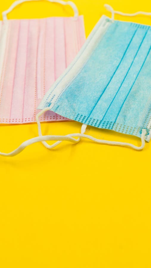 Vertical Shot of Surgical Masks on a Yellow Surface Stock Image - Image ...