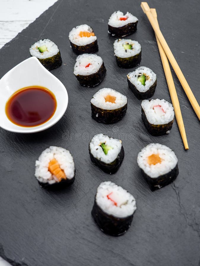 Vertical Shot of Sushi Set with Soy Sauce on a Black Tray Stock Photo ...