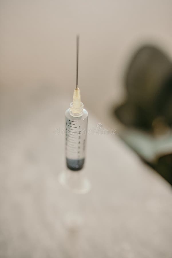 Vertical Shot of a Syringe Against a Light Background Stock Photo ...