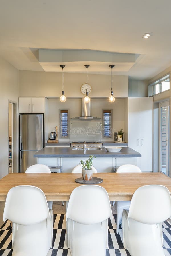 Vertical Shot of a Table with Chairs in the Kitchen of a Modern ...
