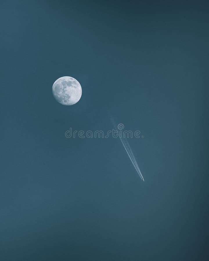 Vertical Shot of a Textured White Full Moon in a Blue Sky with a Flying ...
