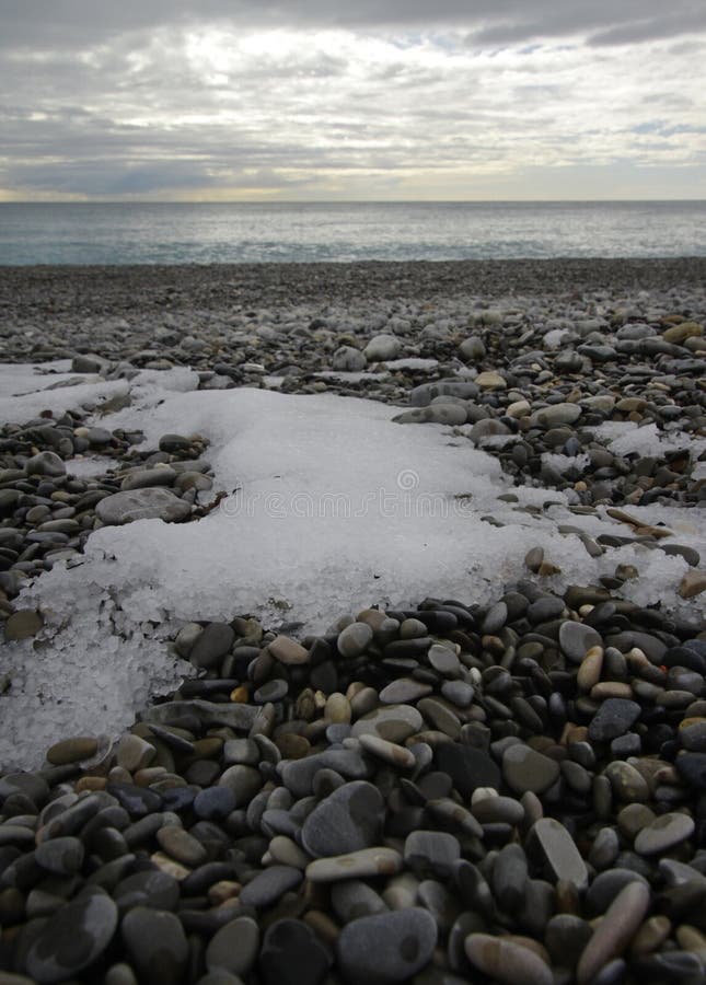 Vertical Shot of Thawing Snow on the Pebbles on the Beach Stock Photo ...