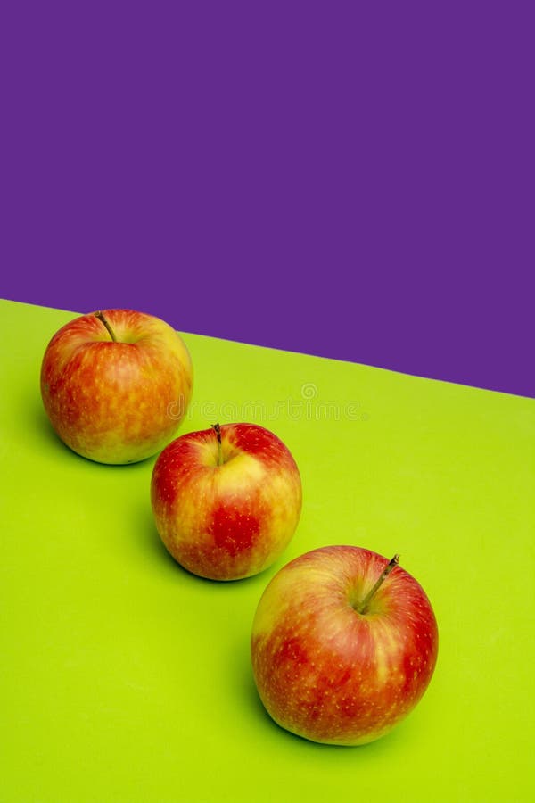 Vertical Shot of Three Apples Put on a Colorful Surface Stock Photo ...
