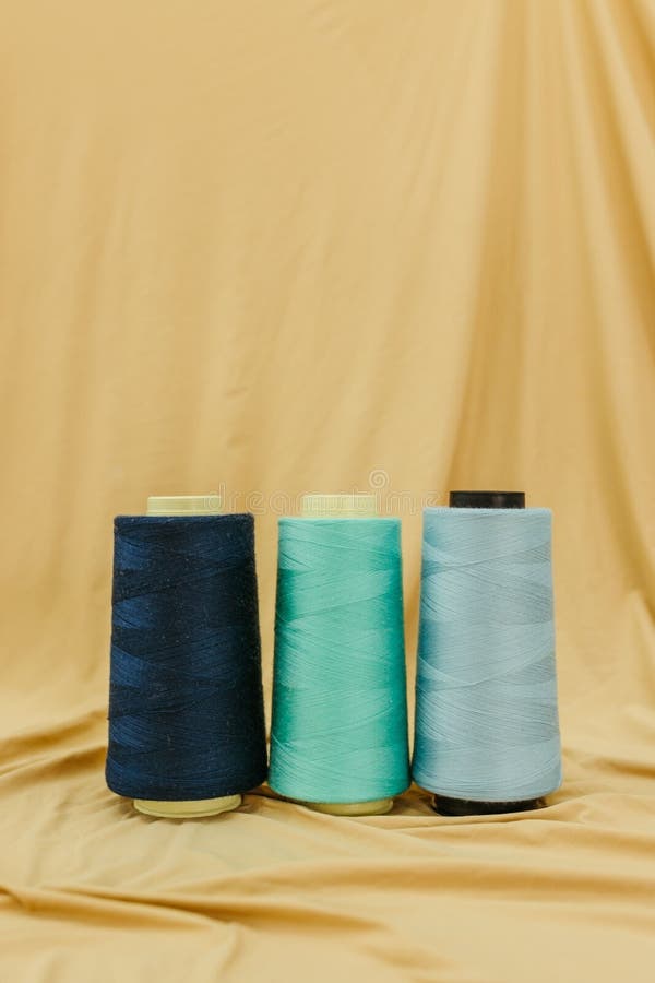 A Vertical Shot of Three Different Colored Spool Threads Stock Photo ...