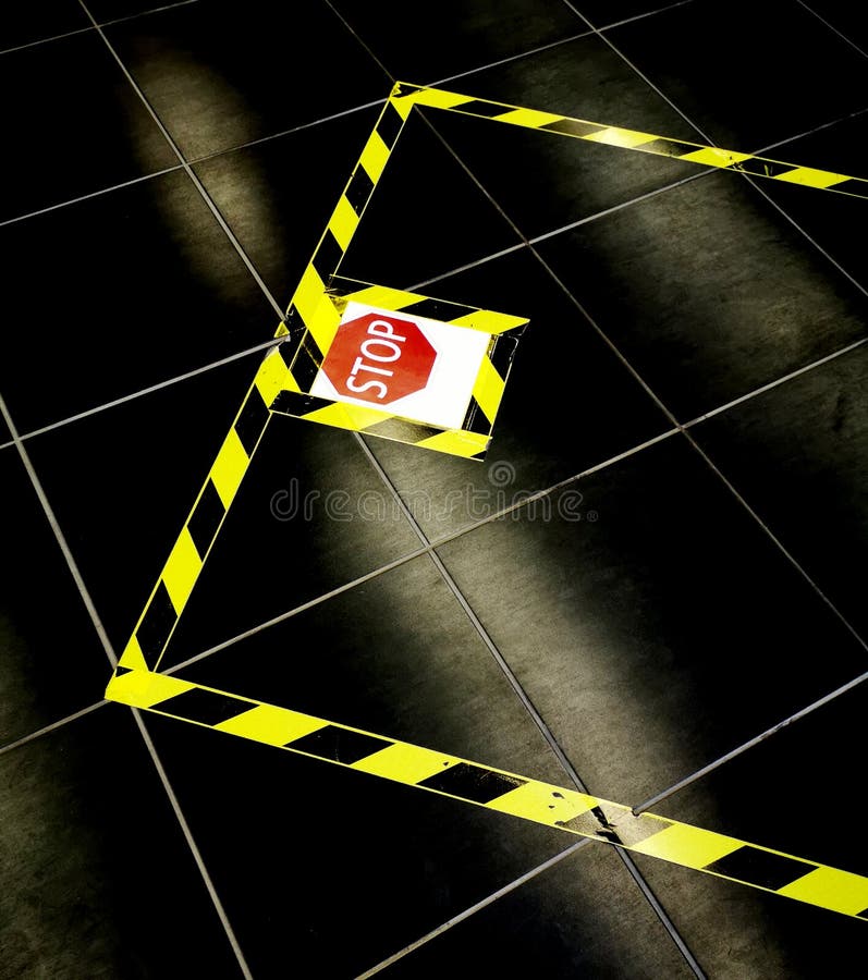 Vertical Shot of a Tiled Black Floor with a Stop Sign and Some Yellow ...