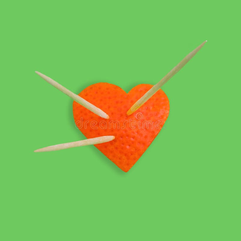 Vertical Shot of Toothpicks on an Orange Heart on a Green Background ...