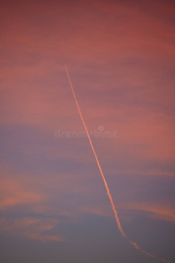 Vertical Shot of the Trail of the Plane in the Colorful Sunset Sky ...