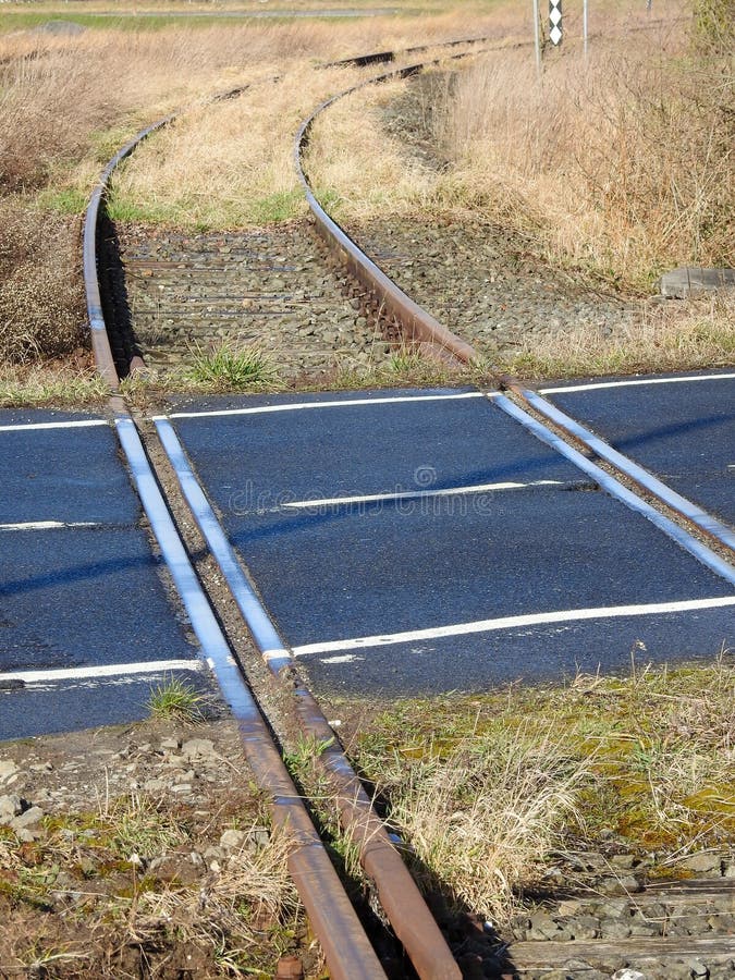Vertical Shot of Train Rails Crossing a Road in the Valley Stock Photo ...