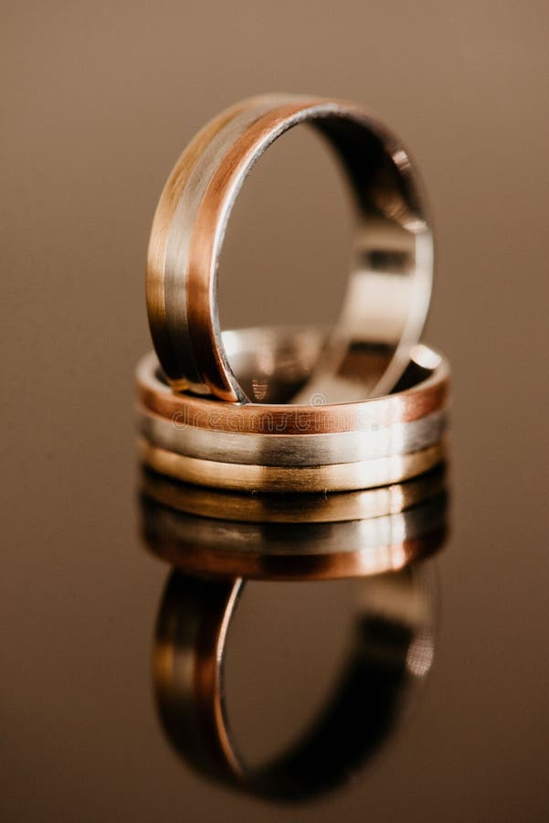 Vertical Shot of the Two Beautiful Wedding Rings Reflected in the Glass ...