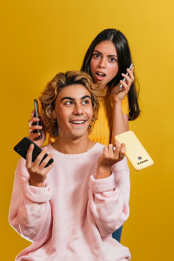 Vertical Shot of Two Caucasian Models Posing with Smartphones in Front ...