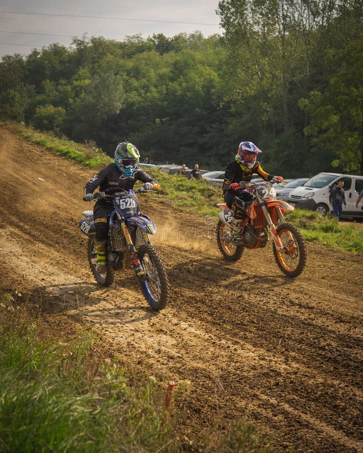 Vertical Shot of Two Sportsmen Riding at an Off-road Motorcycle Racing ... Vertical Shot of Two Sportsmen Riding at an Off-road Motorcycle Racing ...