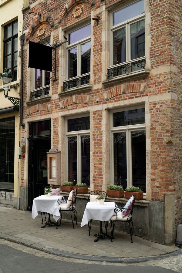 Vertical Shot of Two Tables and Chairs in Front of a Hotel Building ...