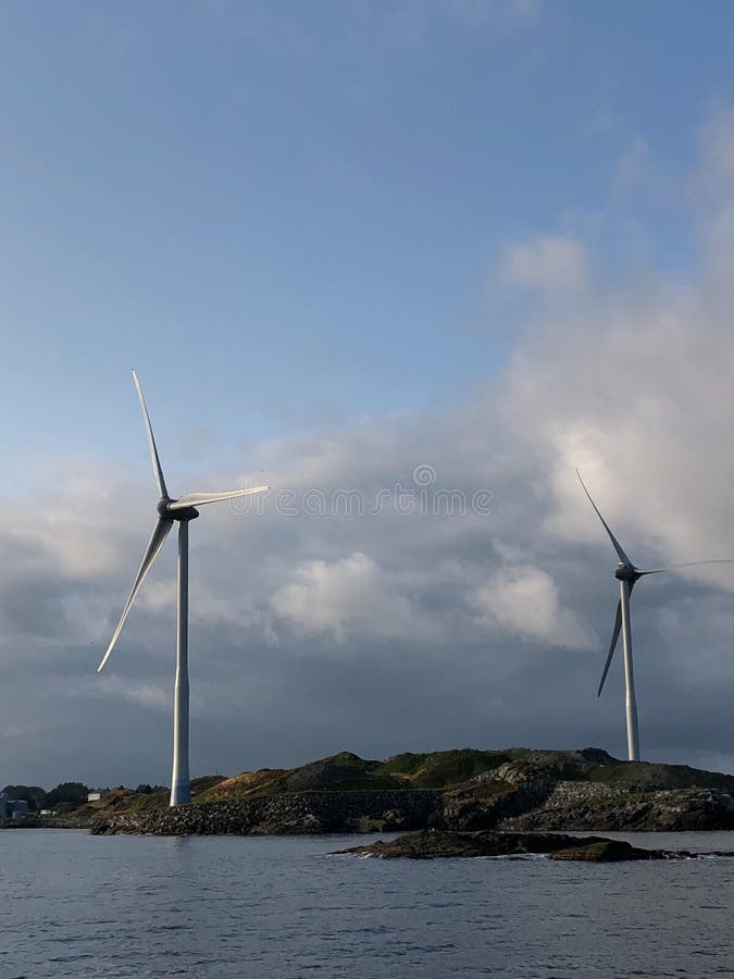 Vertical Shot of Two White Wind Turbines Under a Clouded Sky Stock ...