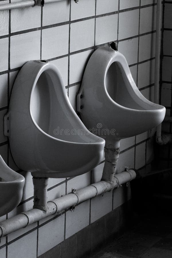 Vertical Shot of Urinate Bowls in the Bathroom Stock Image - Image of ...