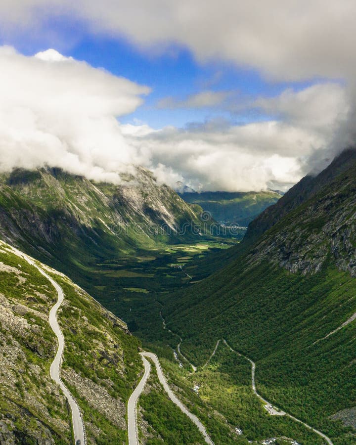 Vertical Shot of a Valley between High Mountain Ranges Under the Clouds ...