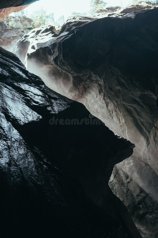 Vertical Shot of a View from Inside a Rugged Cave Looking Out through a ...