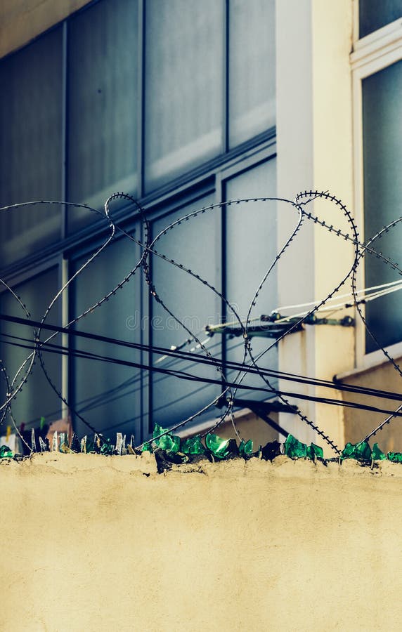 Vertical Shot of a Wall with Barbed Wire Stock Photo - Image of barbed ...