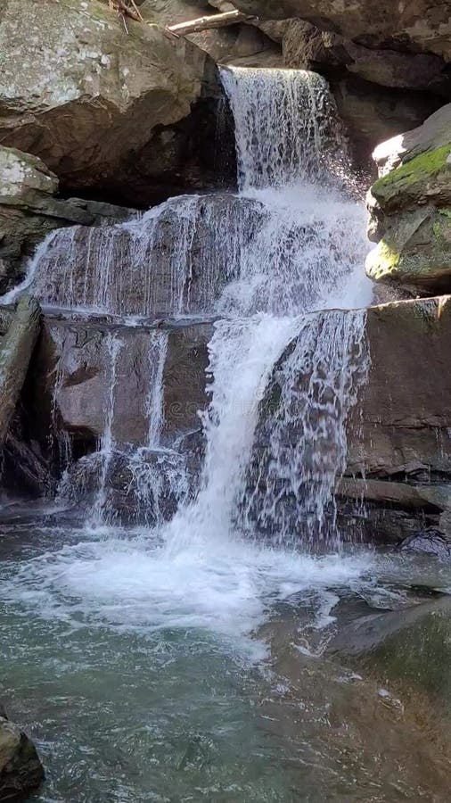 Vertical Shot of Water Falling from a Waterfall Over Stones into a ...