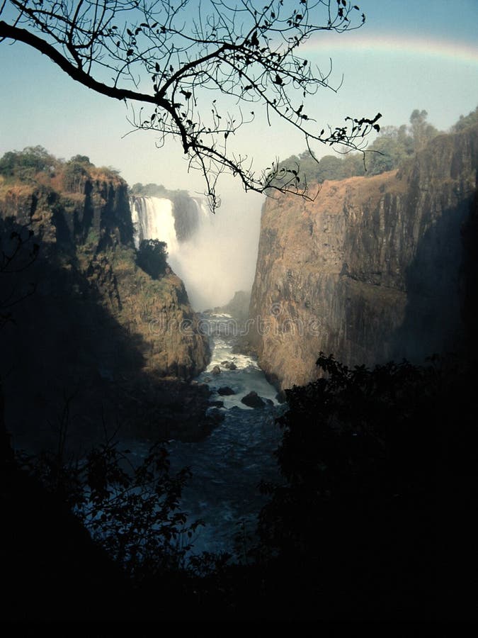 Vertical Shot of a Water Stream in the Middle of Cliffs and a Waterfall ...