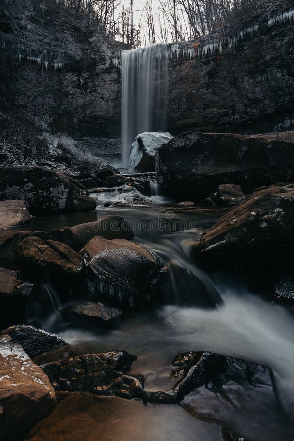 Vertical Shot of a Waterfall Cascading Down between Large Rocks Stock ...