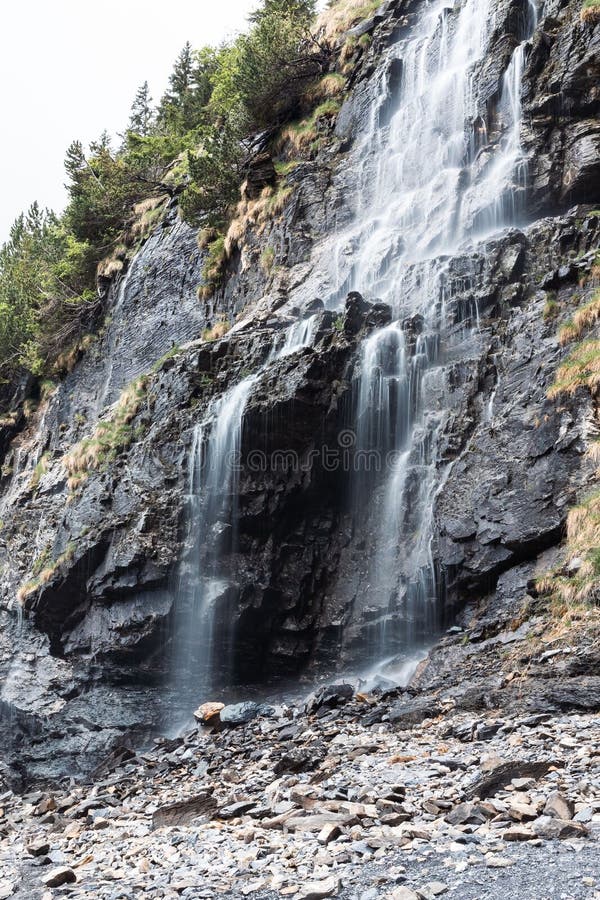 Vertical Shot of a Waterfall Cascading Over a Rocky Mountain. Stock ...