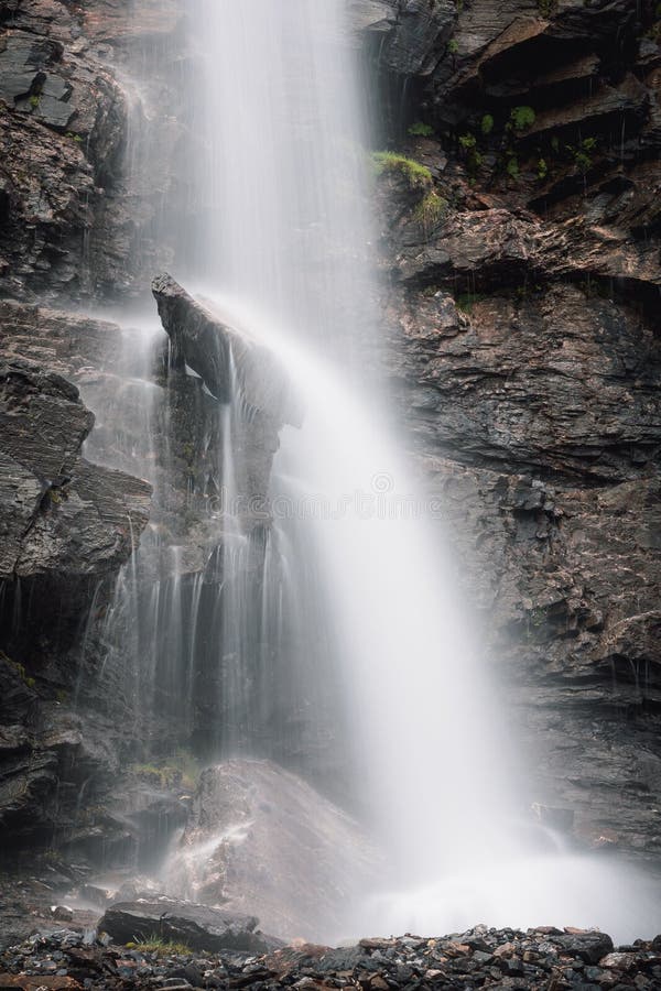 Vertical Shot of a Waterfall Cascading Over a Rocky Mountain. Stock ...