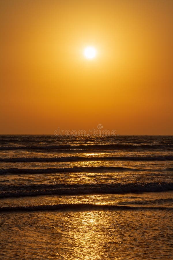 Vertical Shot of a Wavy Ocean Under an Orange Sunset Sk Stock Image ...