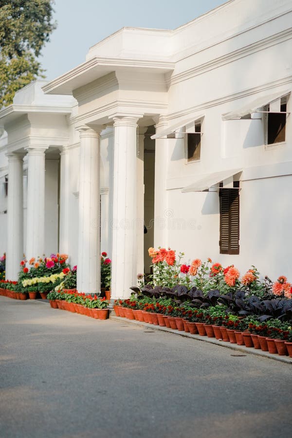 Vertical Shot of a White Building Facade Decorated with Flowers in Pots ...