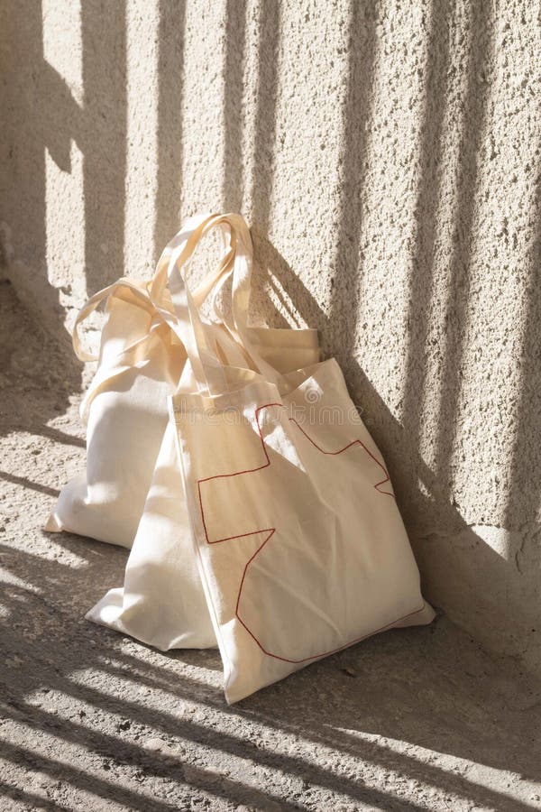 Vertical Shot of the White-colored Tote Bags on the Ground by a Wall ...