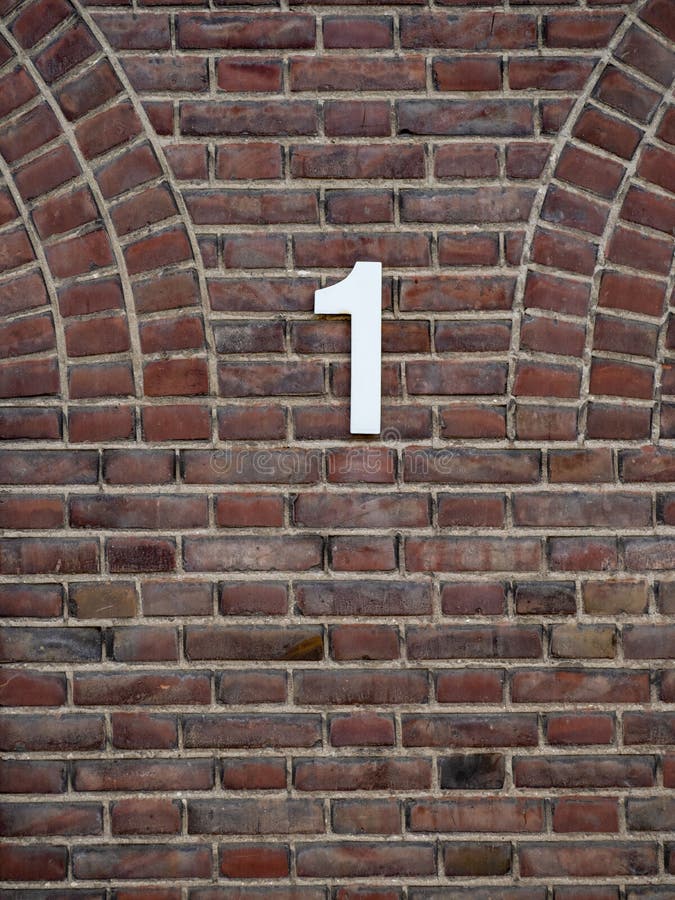 Vertical Shot of a White Number One Sign on a Brick Wall Stock Image ...
