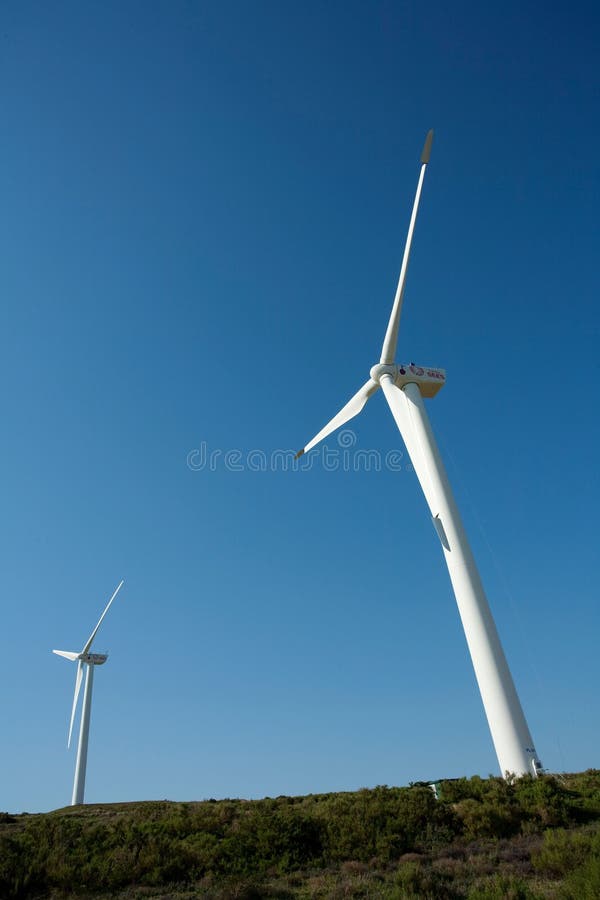Vertical Shot of a Wind Power Turbine on a Hill with a Blue Sky ...