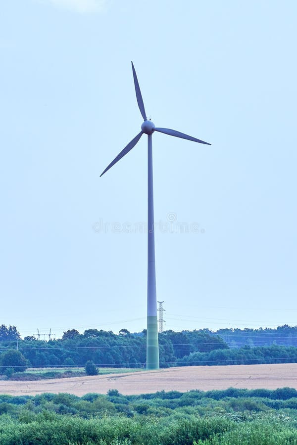 Vertical Shot of a Wind Turbine with Rotating Blades in a Field Stock ...