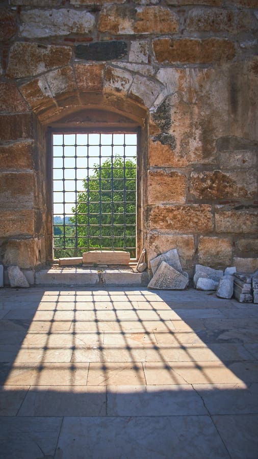 Vertical Shot of a Window with Metal Bars Casting a Shadow at Daytime ...