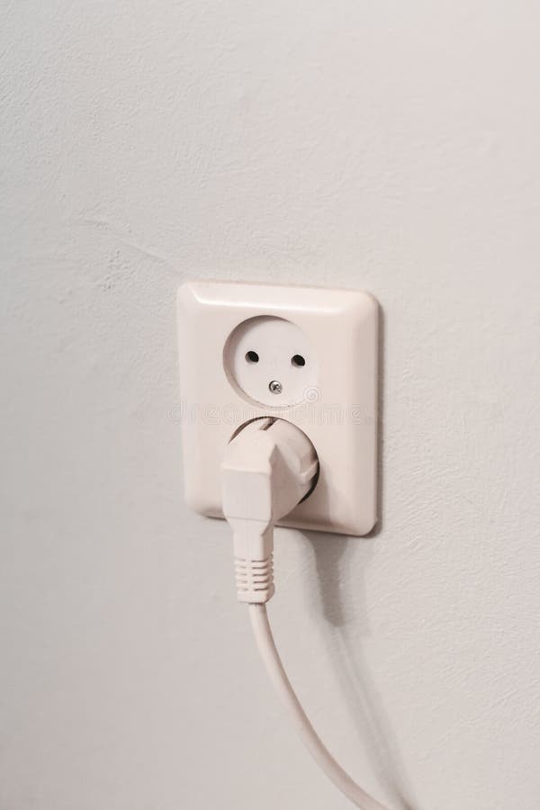 Vertical Shot of a Wire Plugged in the Electrical Socket on a White ...