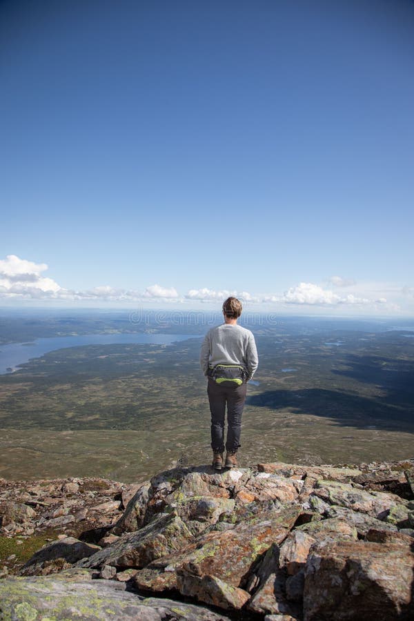 Vertical Shot of a Woman Standing Alone on a Rock and Watching the View ...