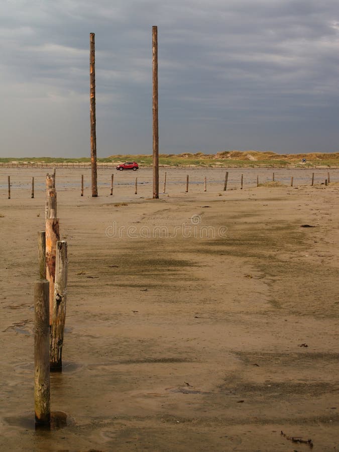 Vertical Shot of Wooden Poles on an Empty Beach at Dusk Stock Photo ...