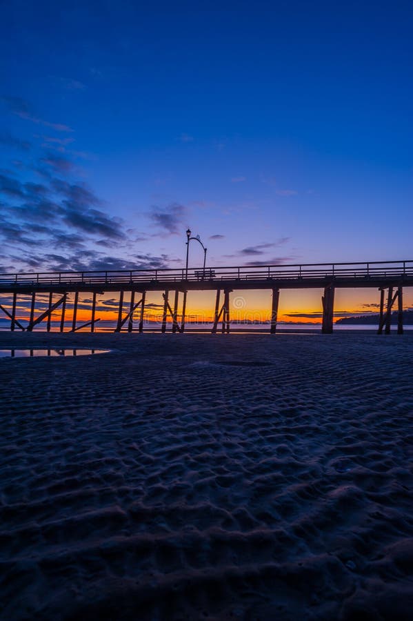 Vertical Shot of a Wooden Port Over the Shore at Sunset Stock Image ...